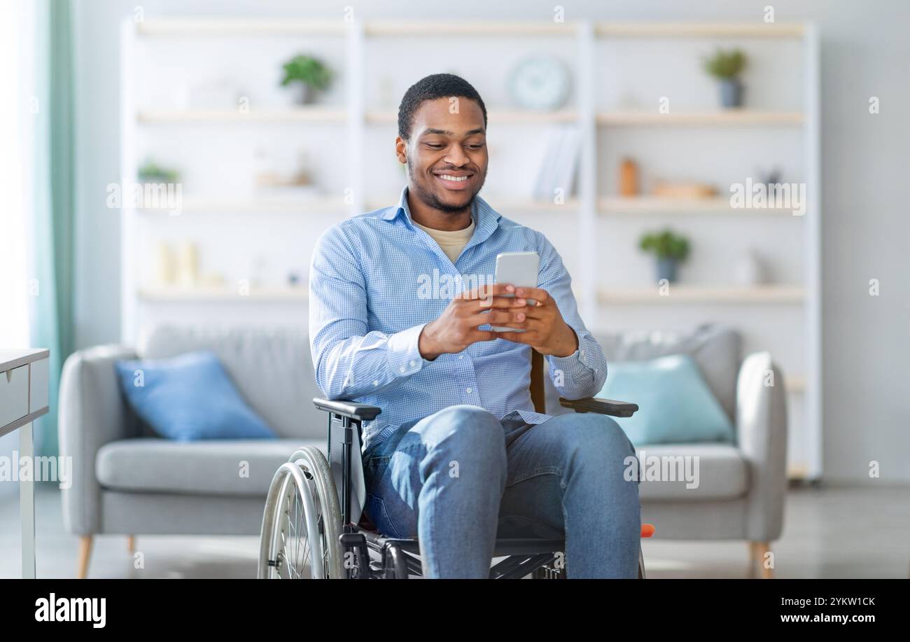 Disabled black man in wheelchair using smartphone, browsing web or ...