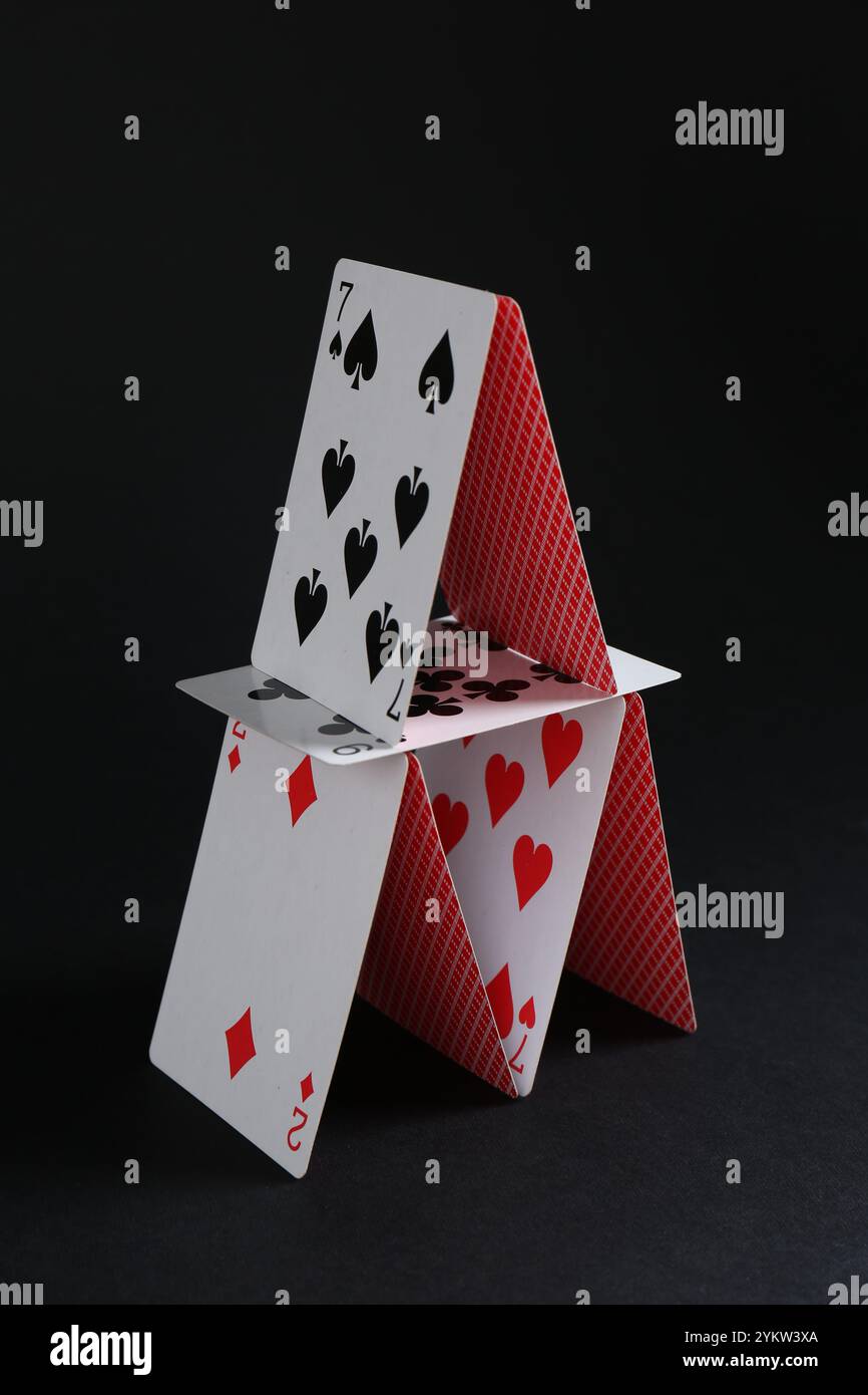 House of playing cards on black background Stock Photo - Alamy