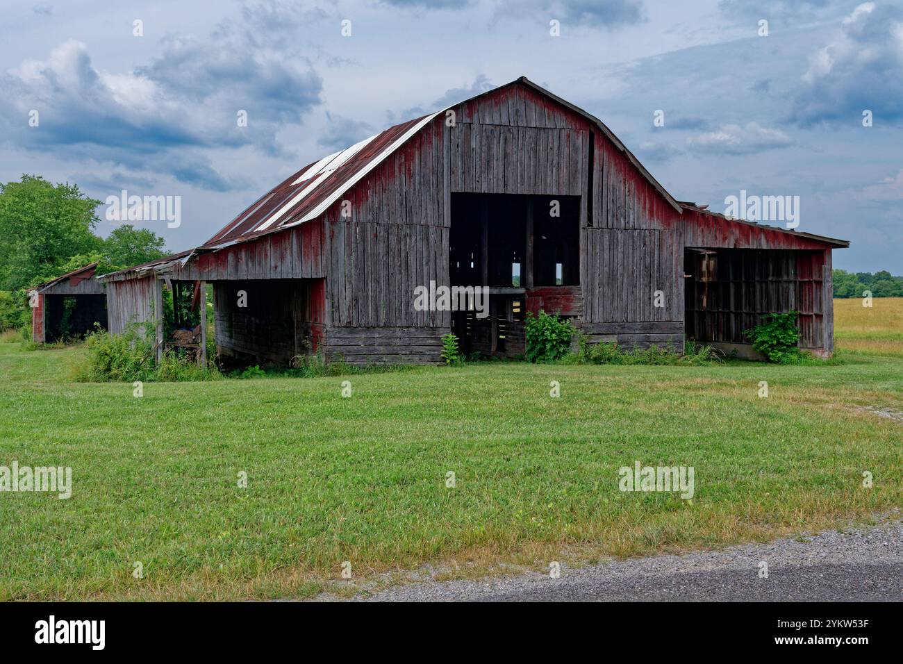 Weathered old red painted barn with the color faded over time and with ...