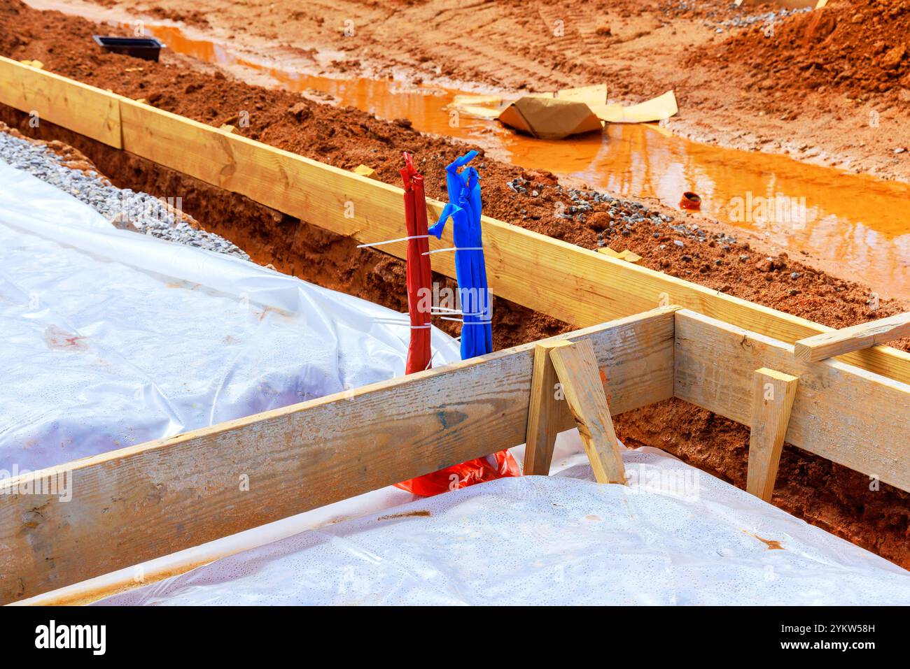Construction site place wooden frames into freshly dug ground, while ...