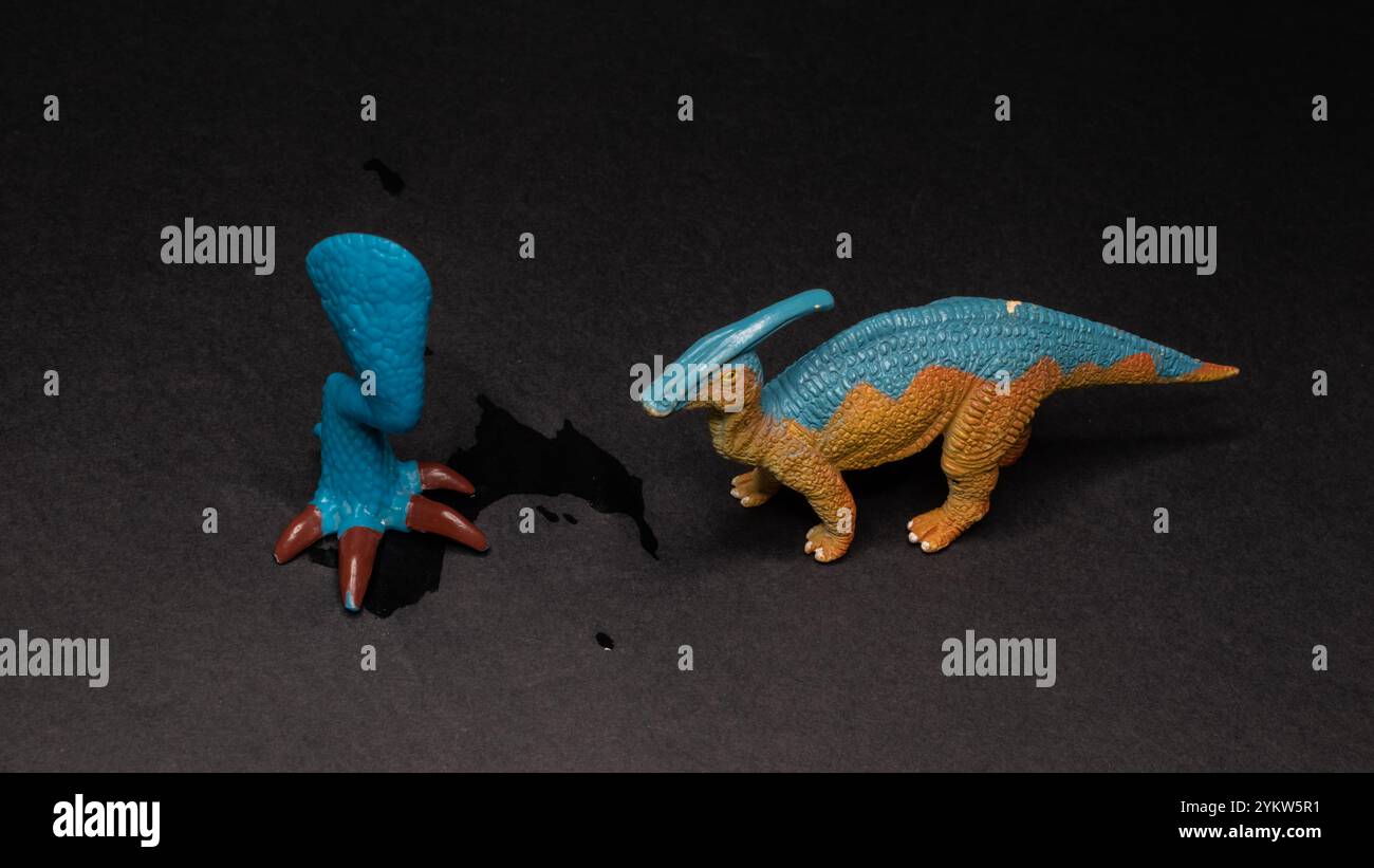 Curious dinosaur looking at large blue monster leg Stock Photo - Alamy