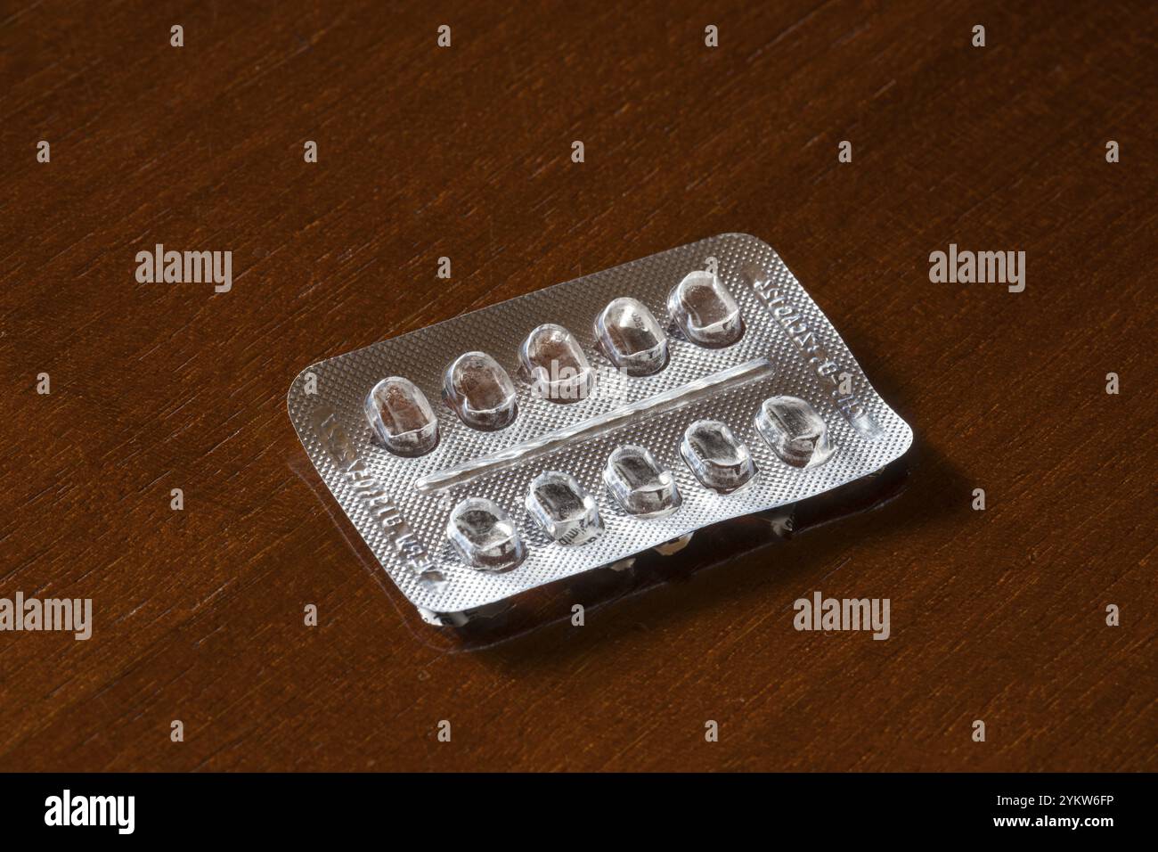 Empty blister packaging on a brown wooden surface Stock Photo - Alamy