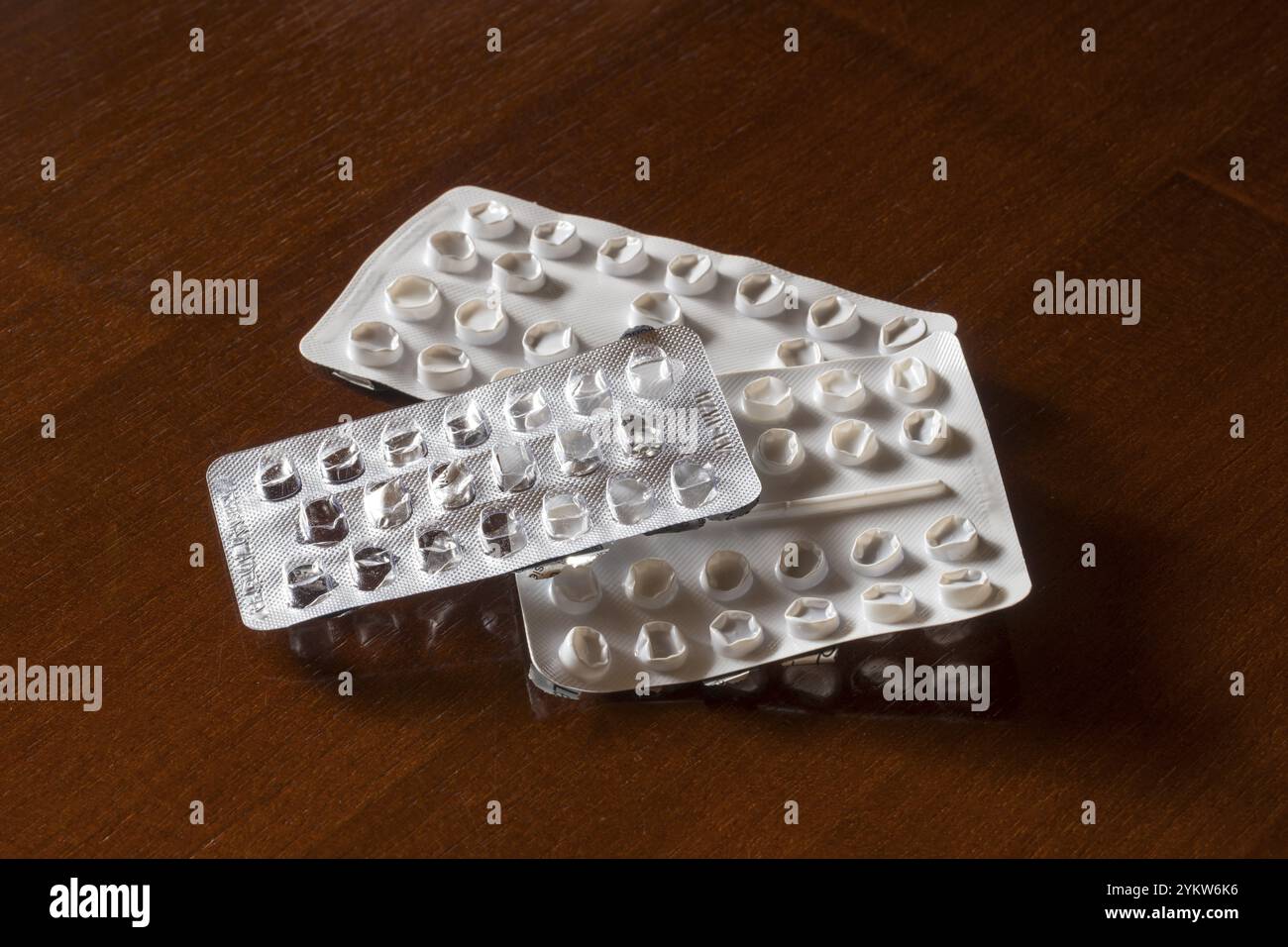 Empty blister packs on a brown wooden surface Stock Photo - Alamy