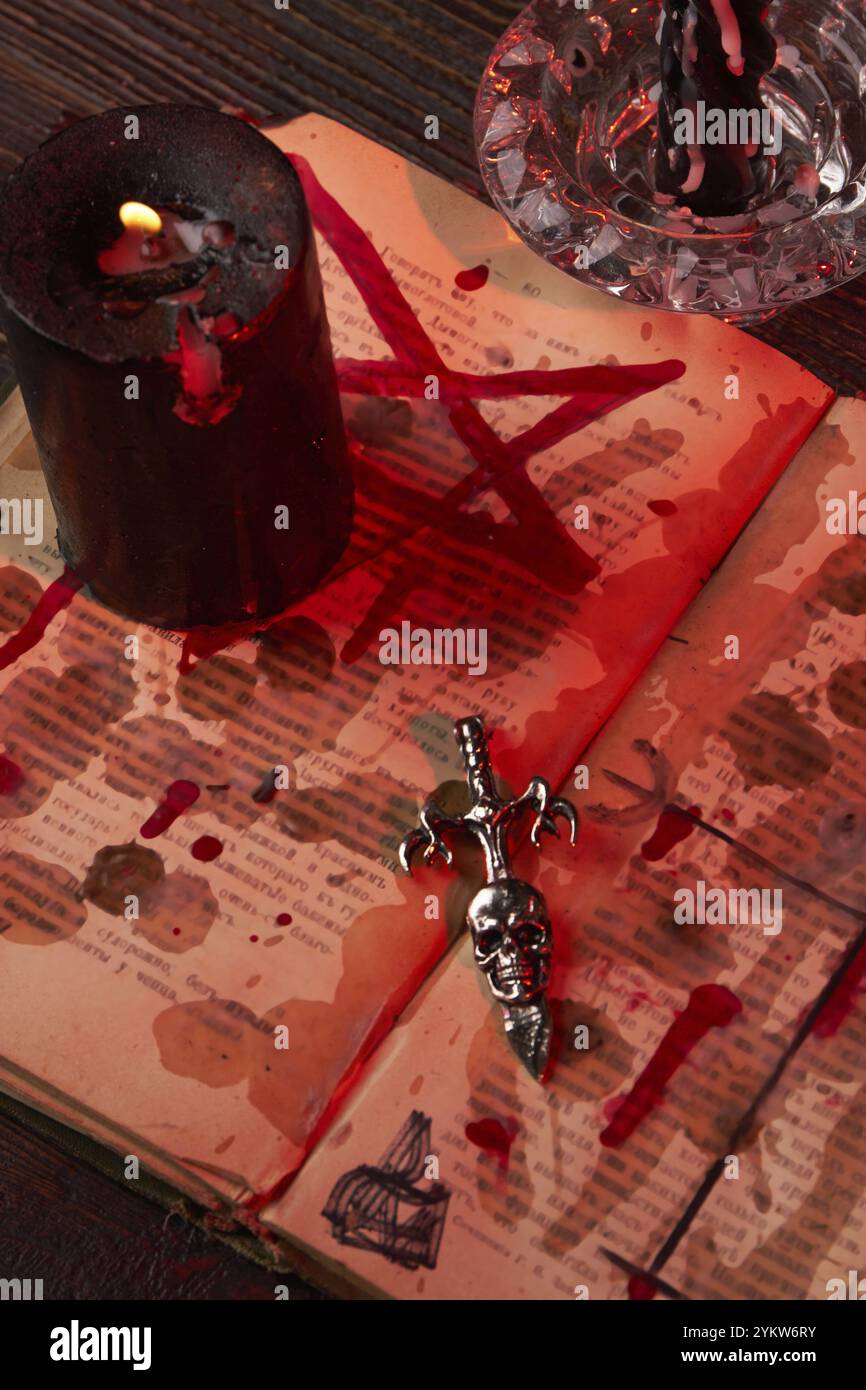 Vertical shot of antichrist cross on the satanic bible stained with ...