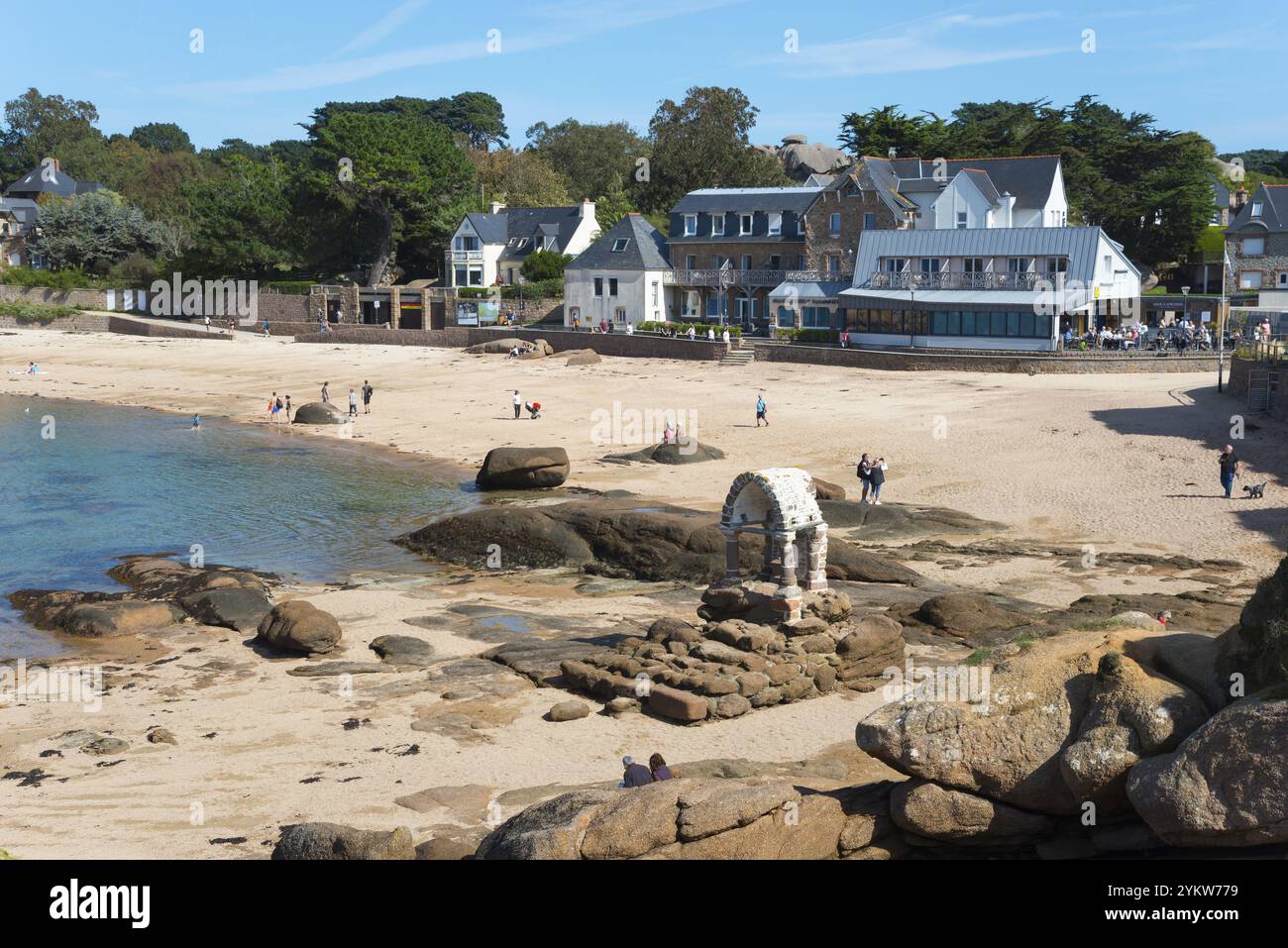 Visitors on the beach of a coastal town with a view of the blue sea and ...