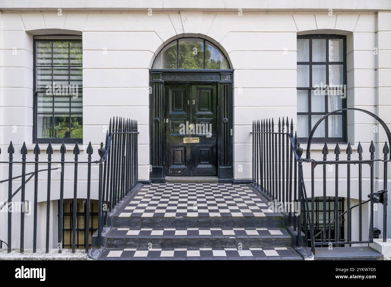 Elegant house entrance with solid black front door and white facade ...