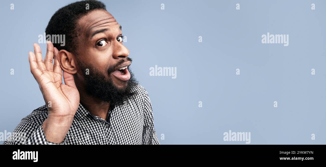 Curious handsome afro guy holding hand near ear Stock Photo - Alamy