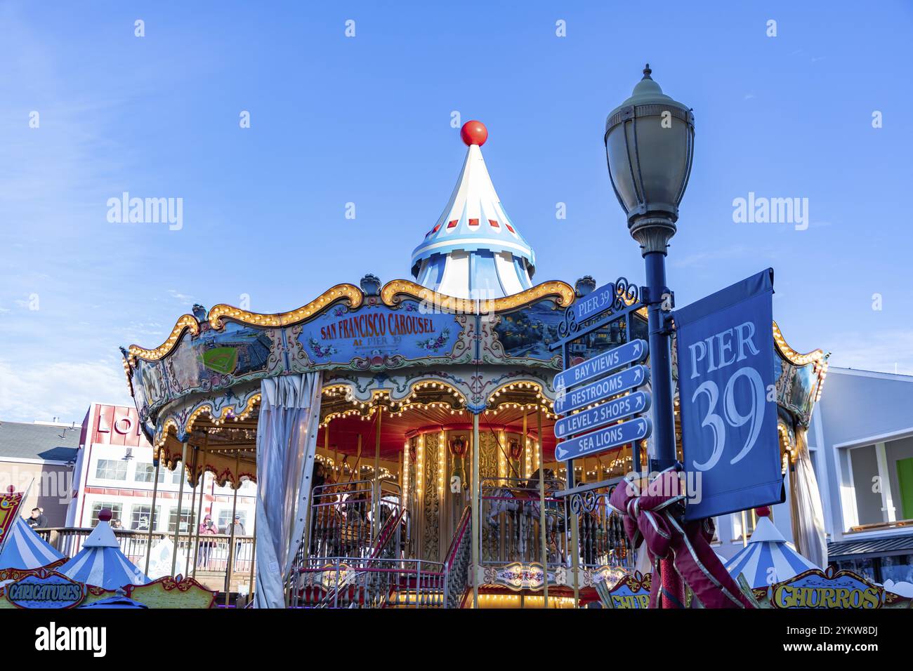 A picture of the signs of Pier 39 next to its iconic colorful carousel ...