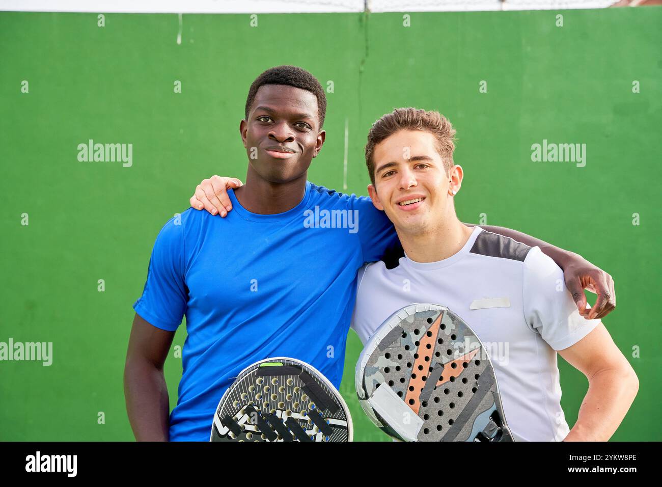 Two men are posing for a picture with their paddle tennis rackets Stock ...