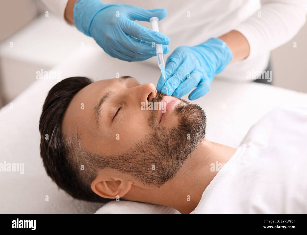 Attractive caucasian man visiting aesthetic clinic, getting lips filler ...