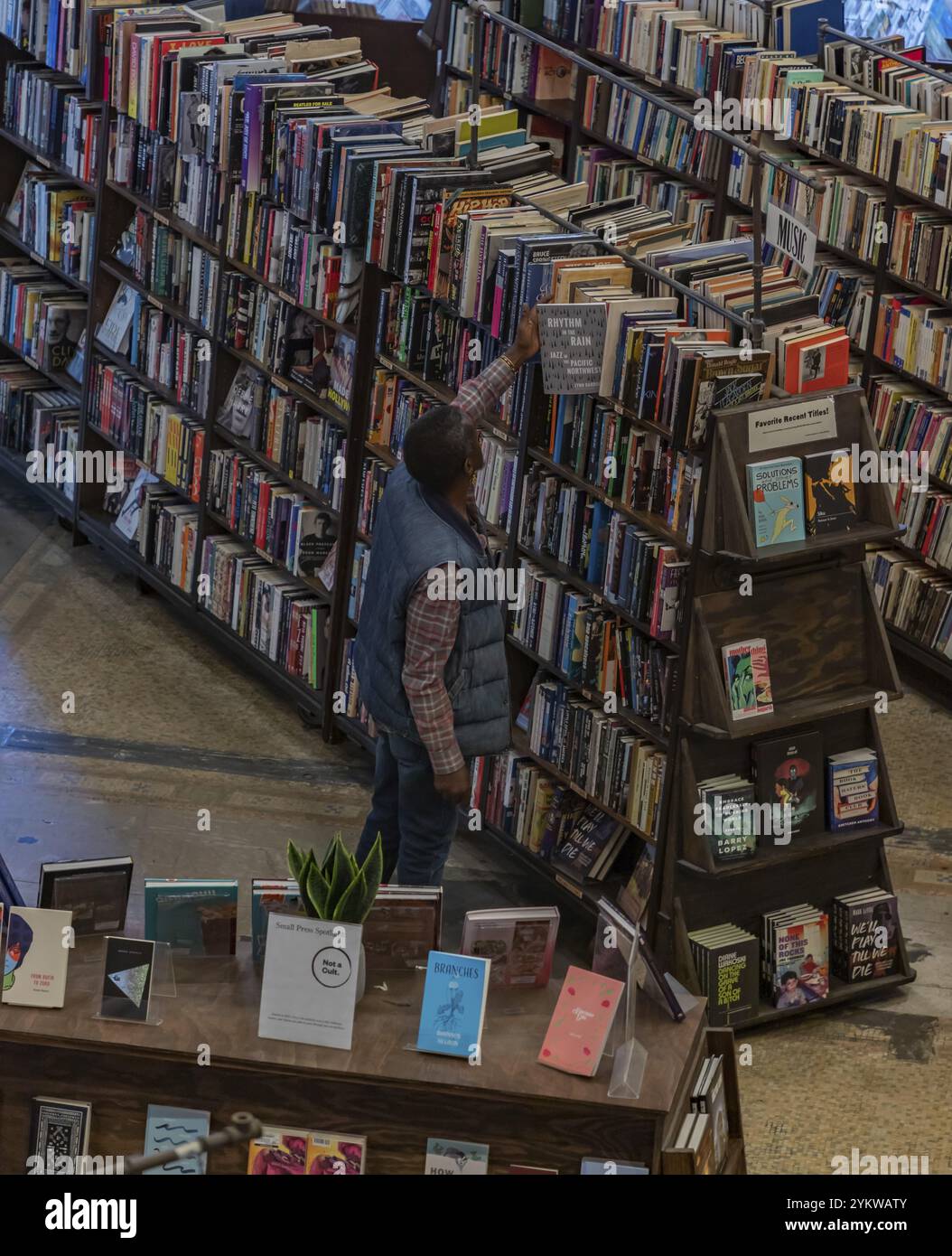 A picture of a man picking up a book inside The Last Bookstore Stock ...
