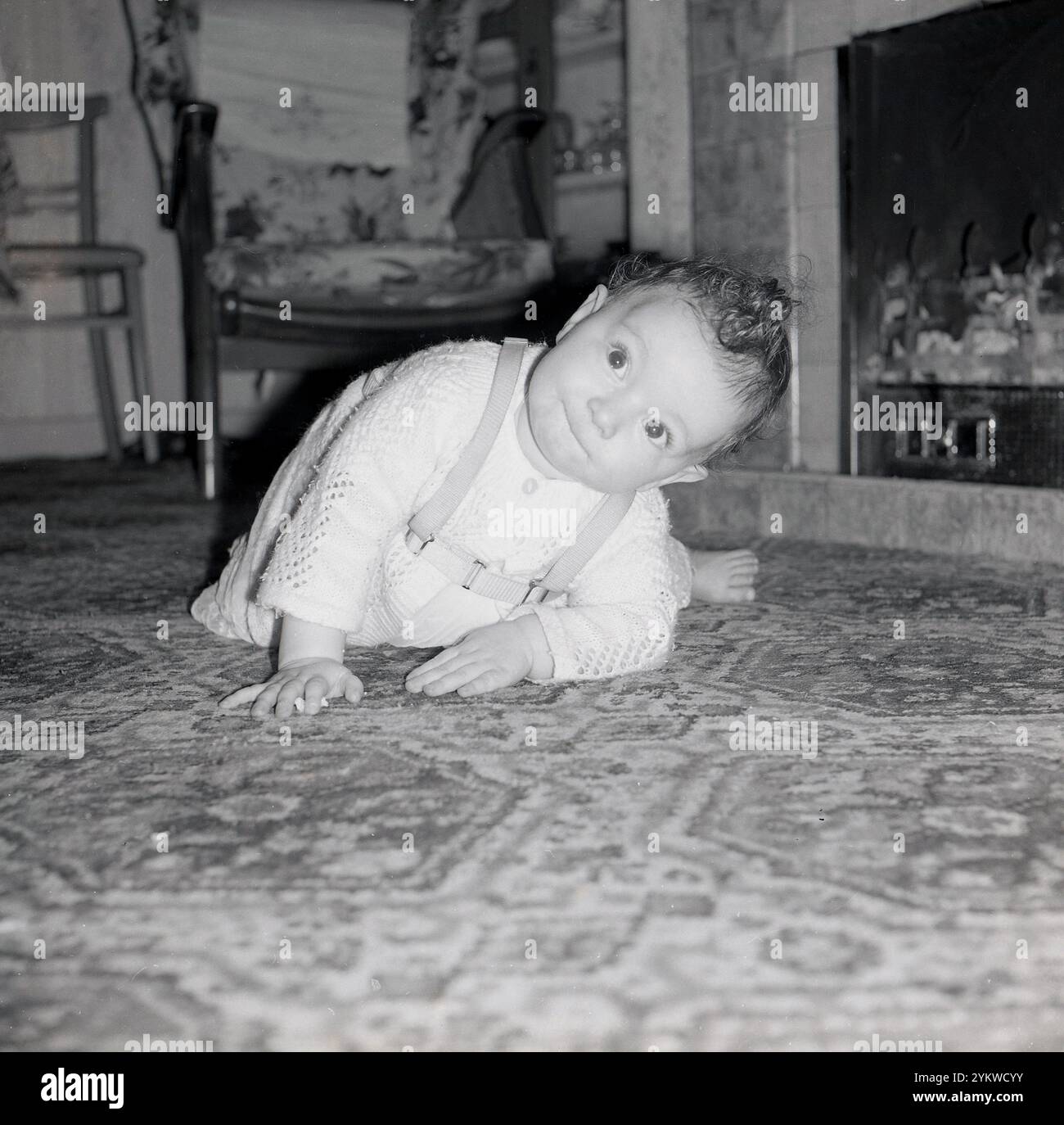 1960s, historical, an infant crawling on the floor of a living room ...