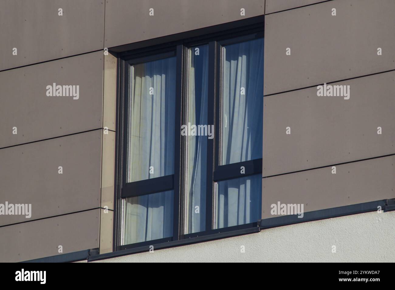 Sunlight illuminating curtains behind a window of a modern residential ...