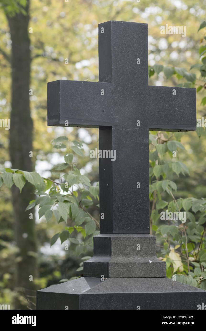 Simple dark stone cross in a cemetery, symbolizing remembrance, faith ...