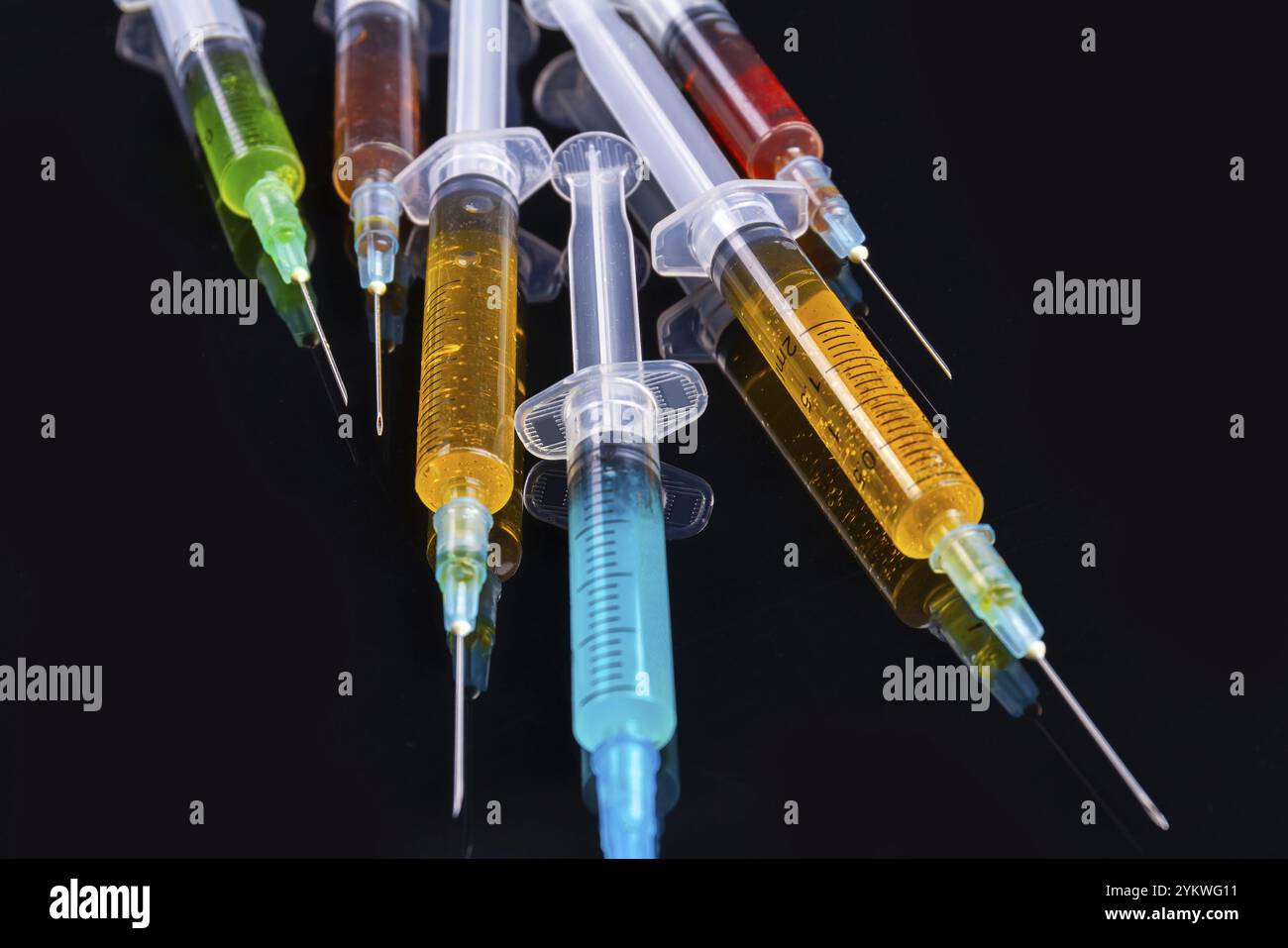 Close-up syringes with colored medicine isolated on black background ...