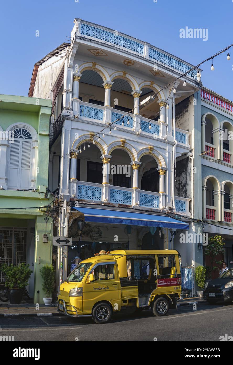 A picture of a yellow tuk tuk in front of the colorful Sino Portuguese ...