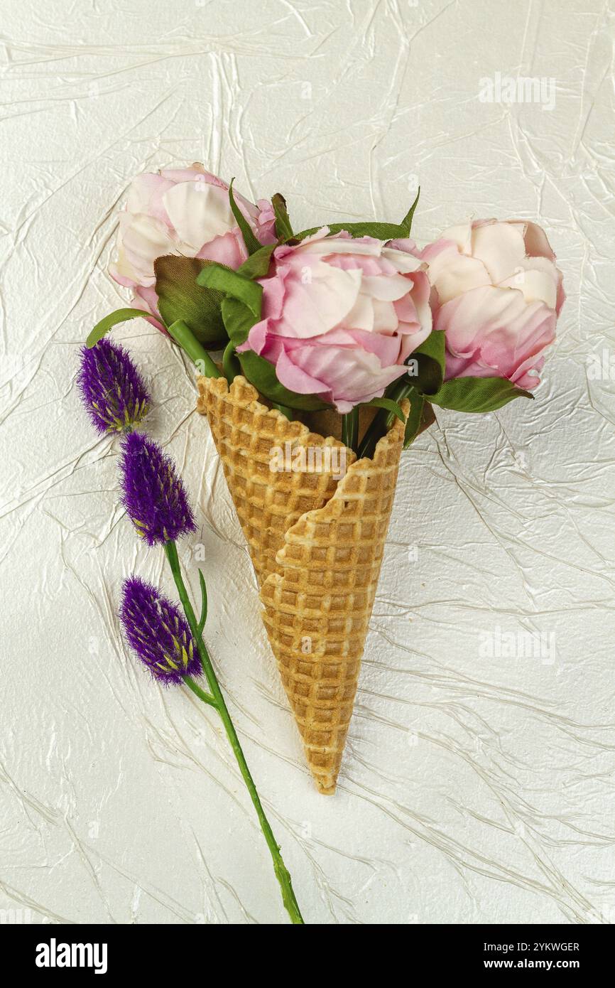 Ice cream cone with flowers and purple clover. Vertical shot white ...