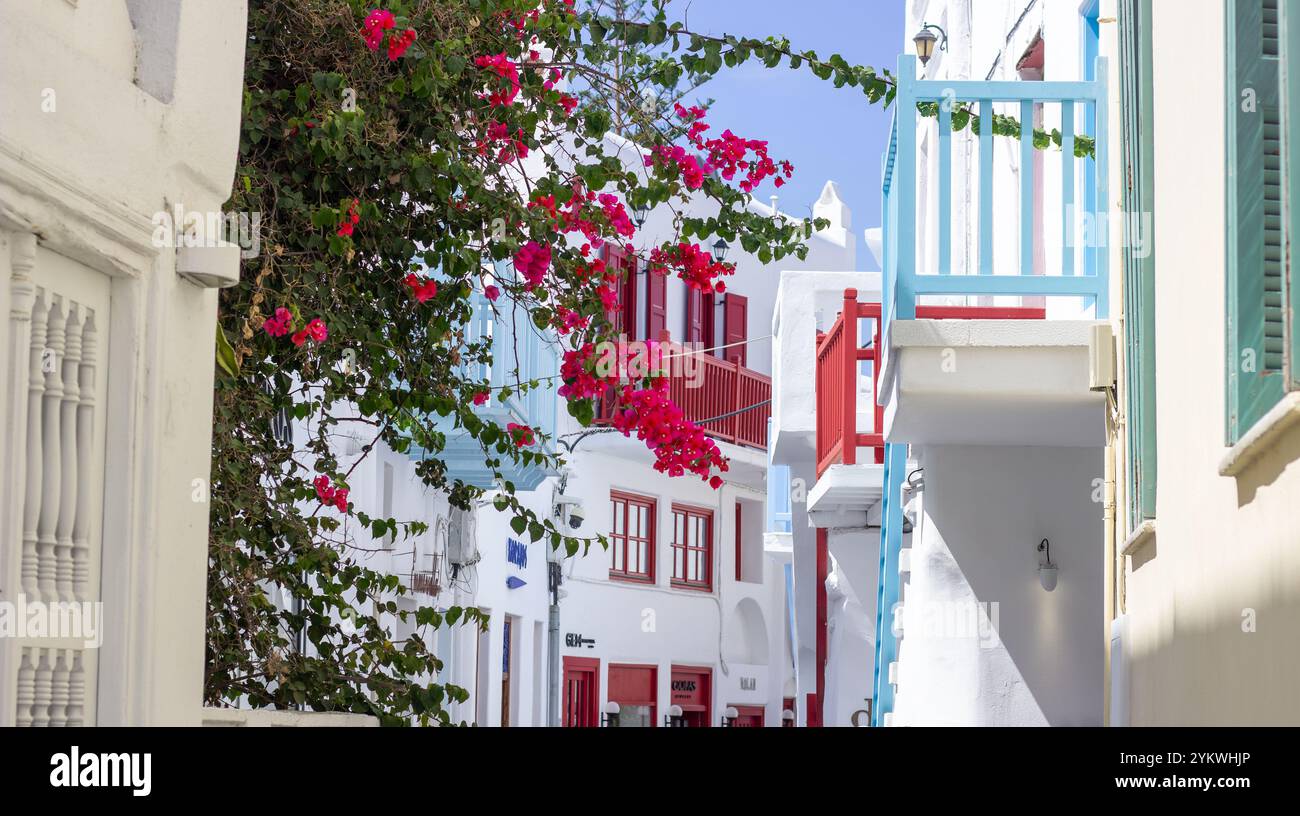 Narrow street in Mykonos with whitewashed buildings, colorful balconies ...