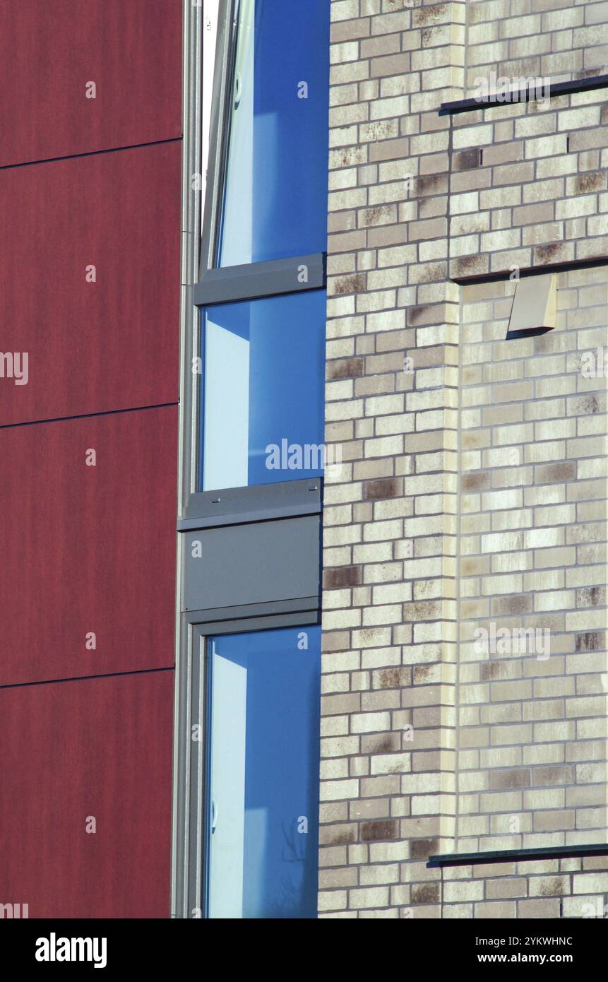 Modern building facade showcasing a blend of brick, red paneling, and ...