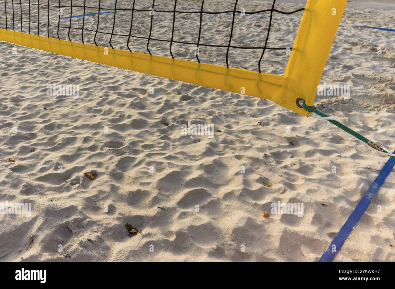Yellow volleyball net casting a shadow on the sand of an empty beach volleyball court Stock ...