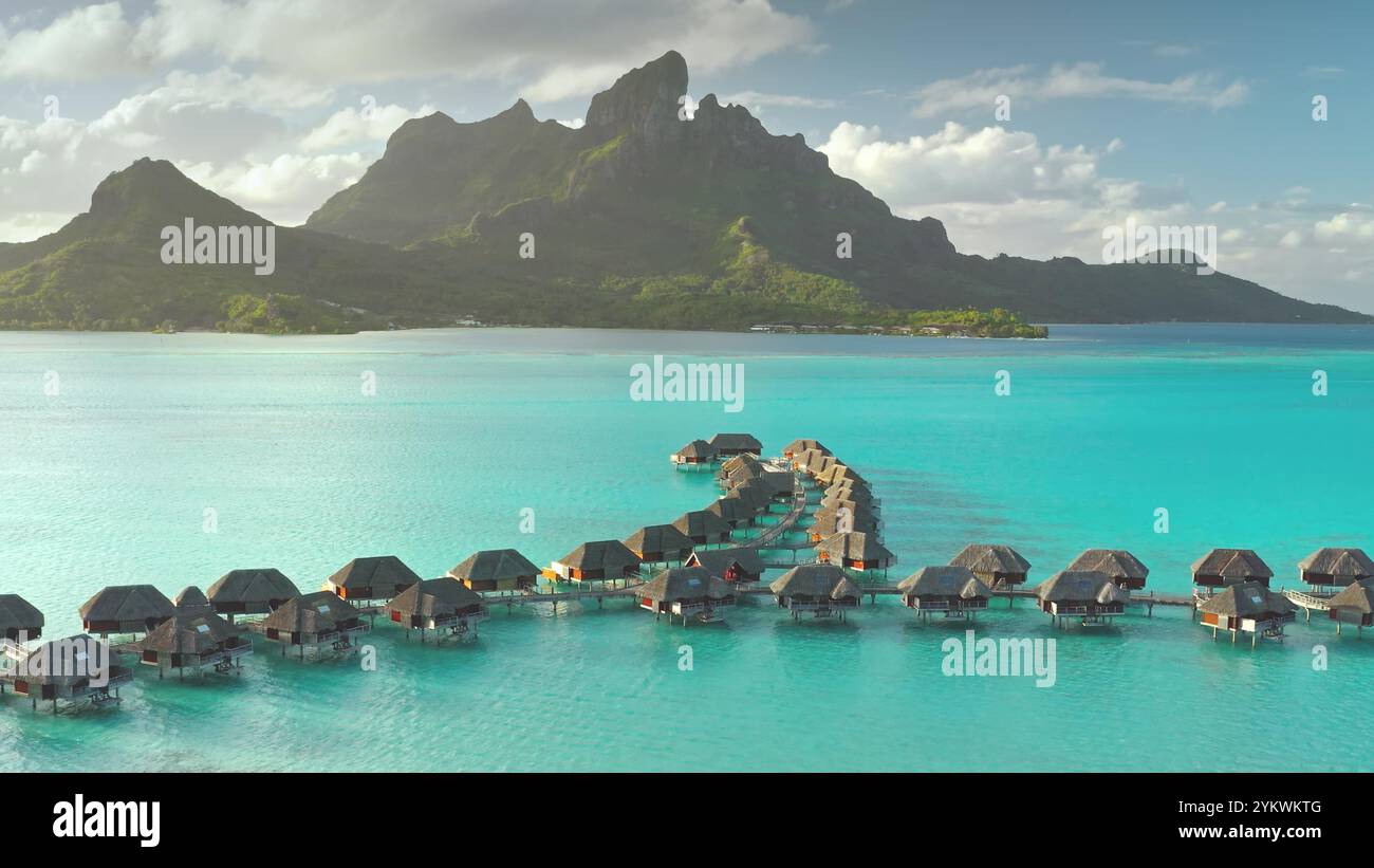 Aerial view overwater bungalows forming line towards mount Otemanu on ...
