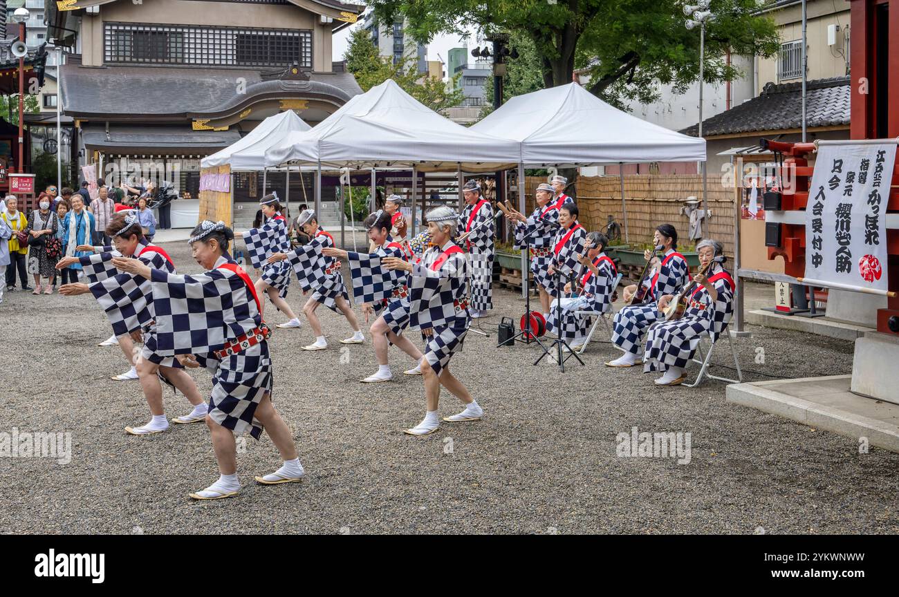 Group of elederly japanese women andmen performaing traditional folk ...