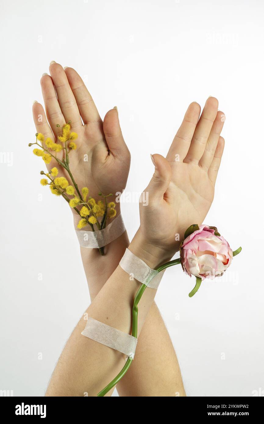 Two crossed female forearms with patched flowers. Vertical shot white ...