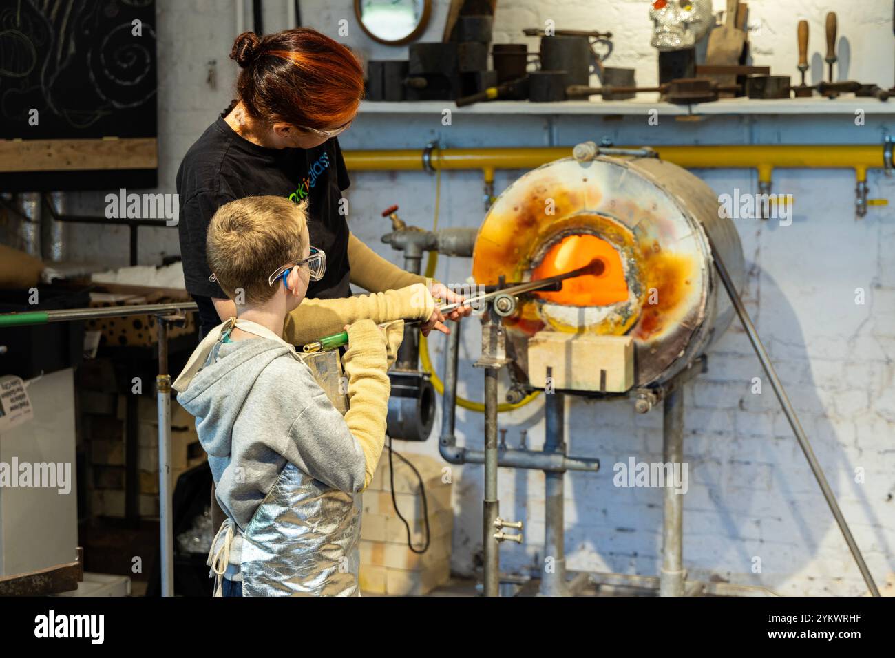 Boy with instructor at glassmaking workshop at The Forge, Hainault Forest Visitor Centre ...