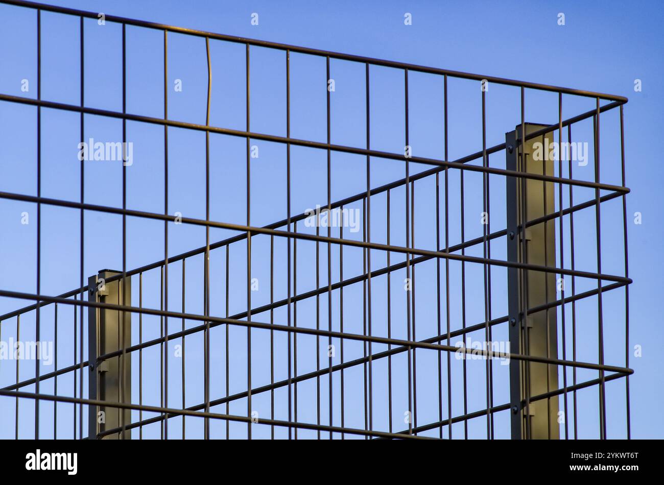 Metal wire mesh fence with supporting posts creating a grid pattern ...