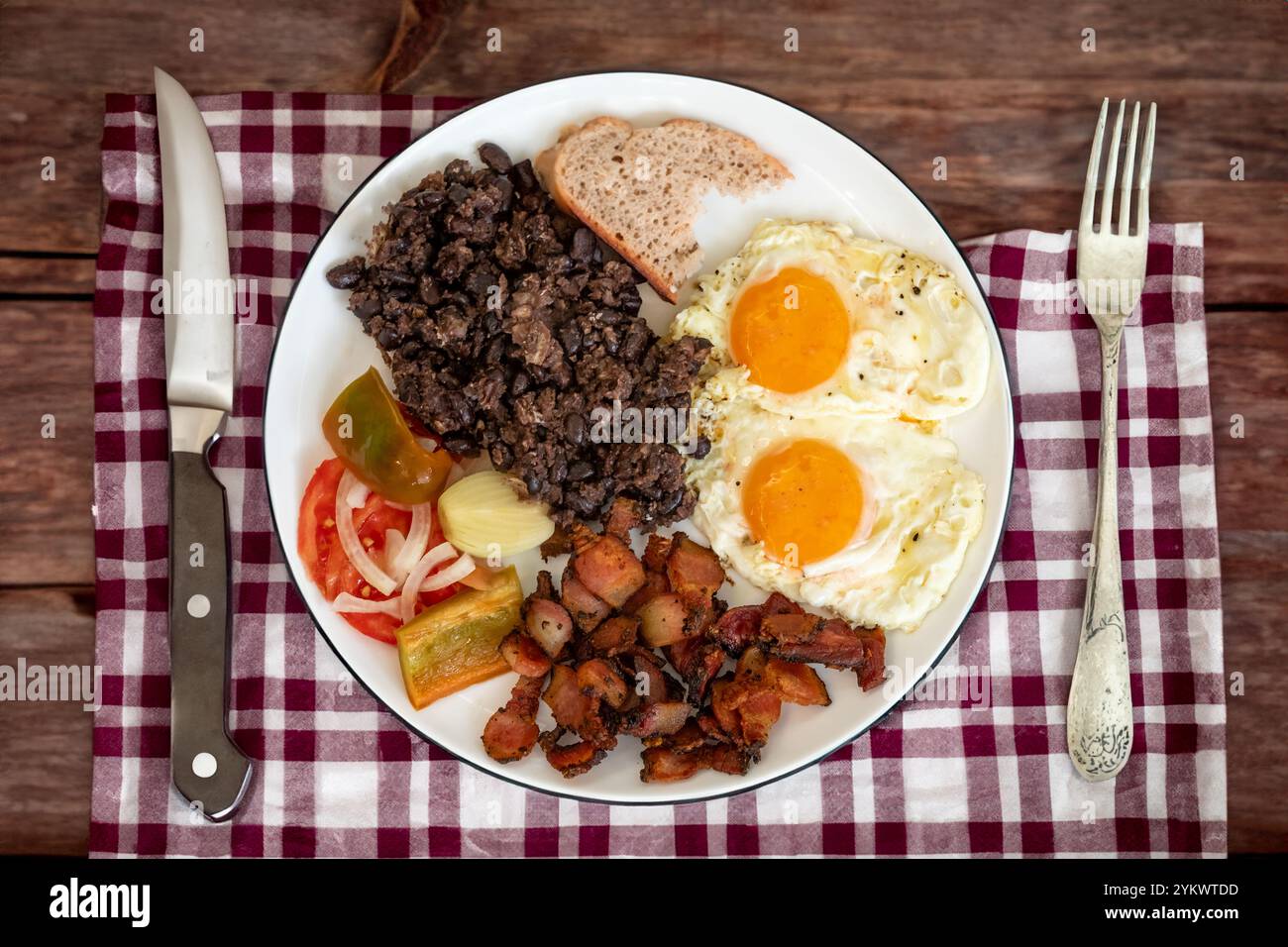 Traditional Brazilian everyday food, black bean stew, bacon, egg, salad ...