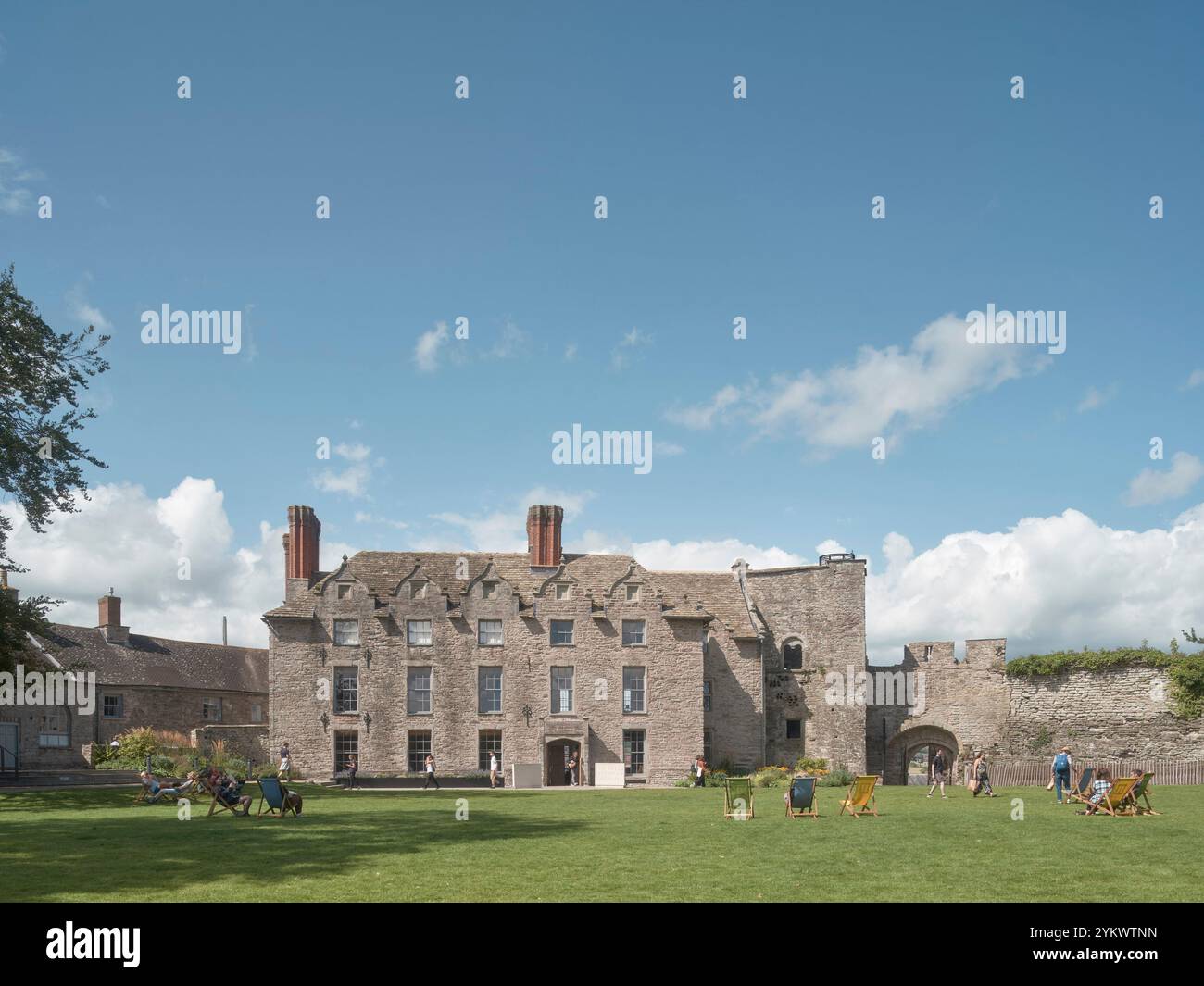 Front elevation from garden with arched gateway and visitors. Hay ...