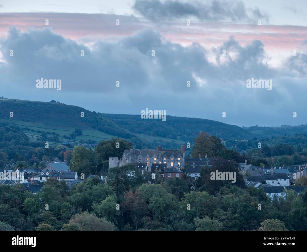 Medieval structure and its context at dusk with glowing interiors. Hay ...