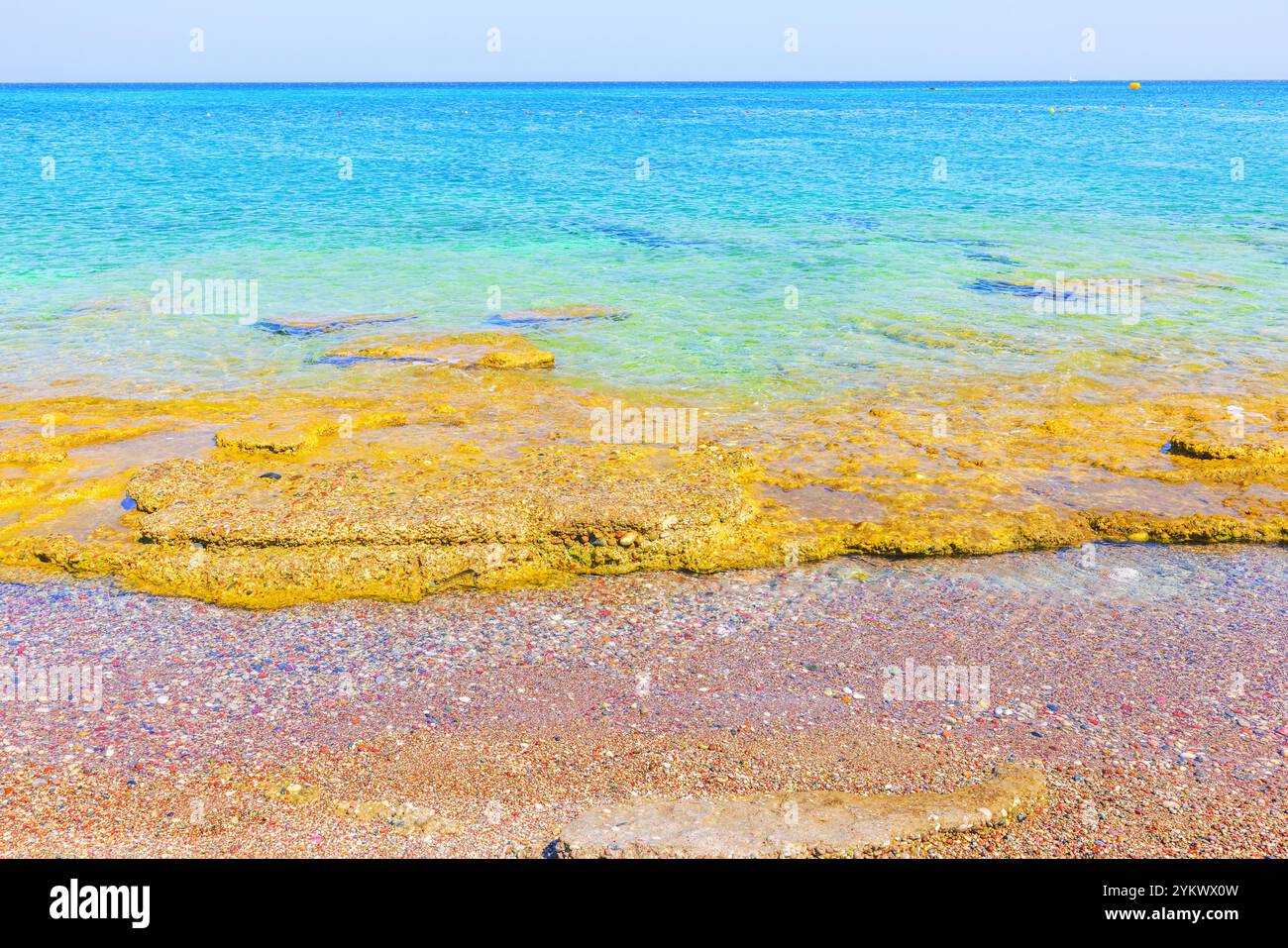 Clear waters of Aegean Sea Rhodes with rocky formations and pebbles ...