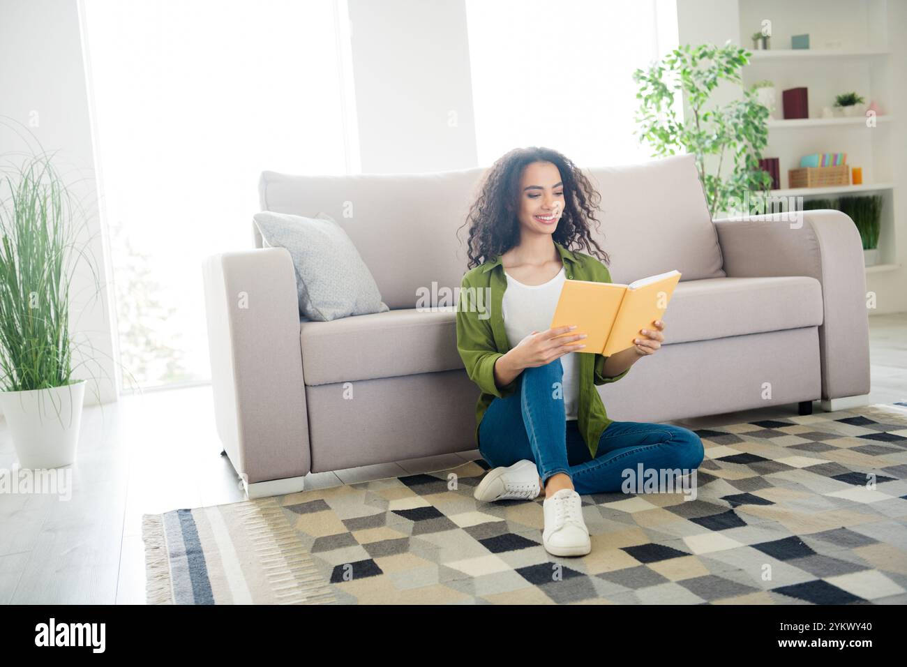 Photo of adorable girl sit floor hold read book literature preparing ...