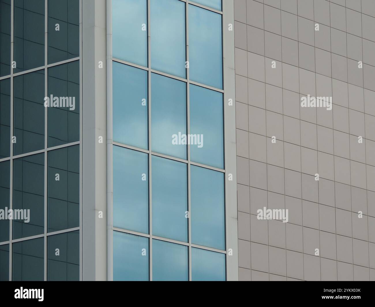 mirror corner of building with blue glass windows and beige square ...