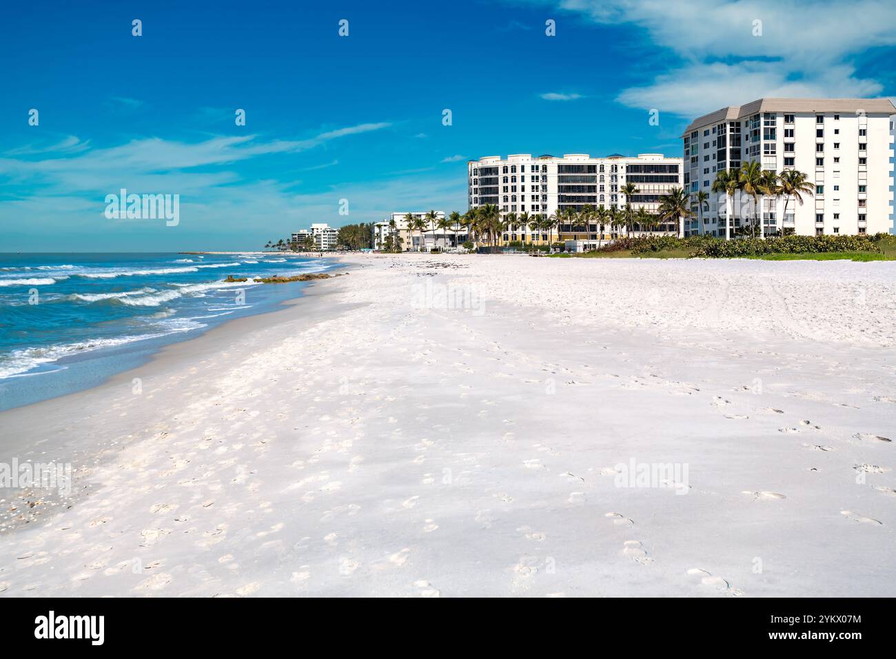 A serene beach in Naples, Florida with soft white sand and skyline of ...
