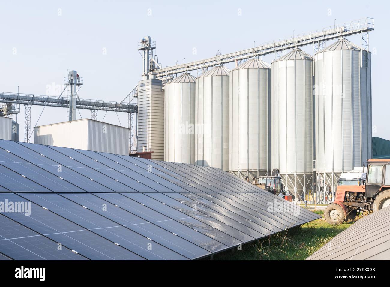 Modern farm using renewable energy. Solar panels with silos in the ...