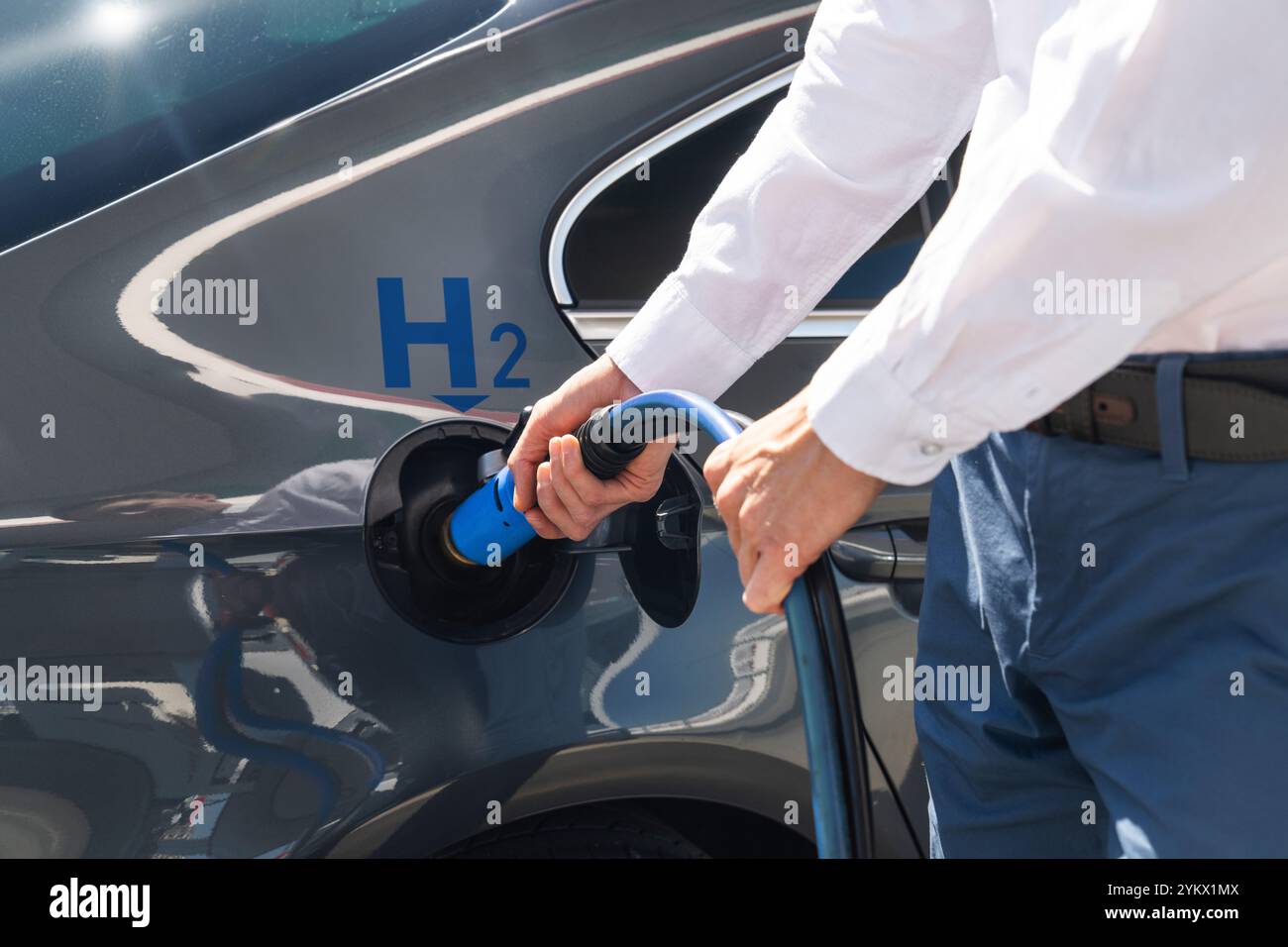 Man holds a hydrogen fueling nozzle on a hydrogen filling station ...