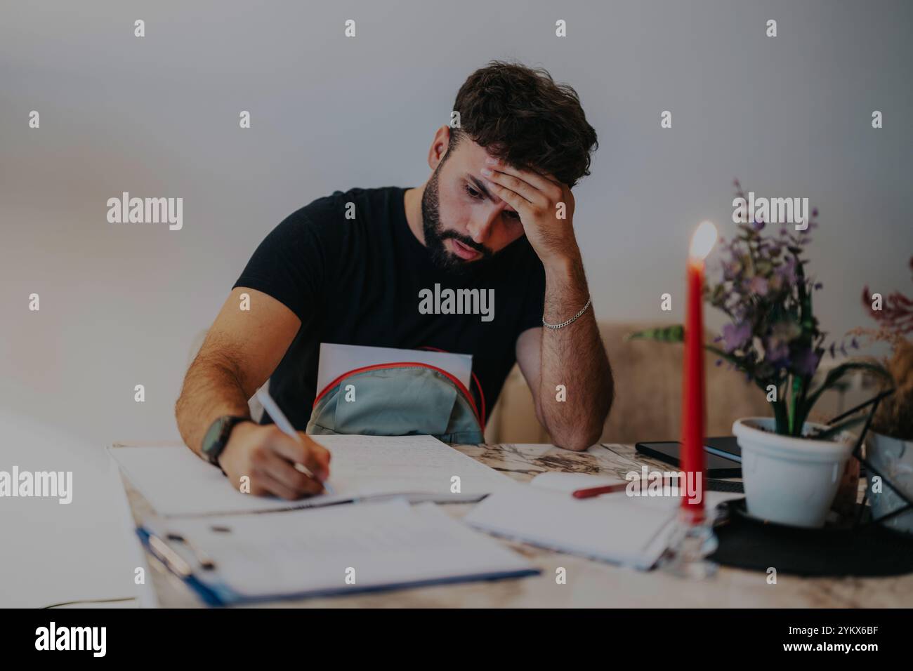 Stressed college student studying by candlelight at home Stock Photo ...