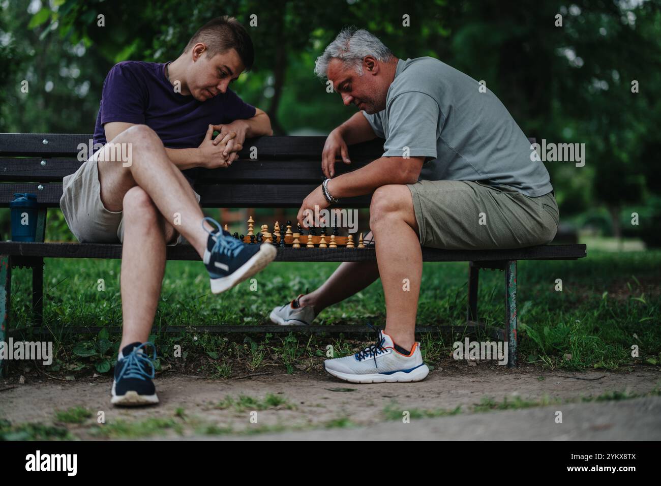Two men playing chess on a park bench during a relaxing day Stock Photo ...