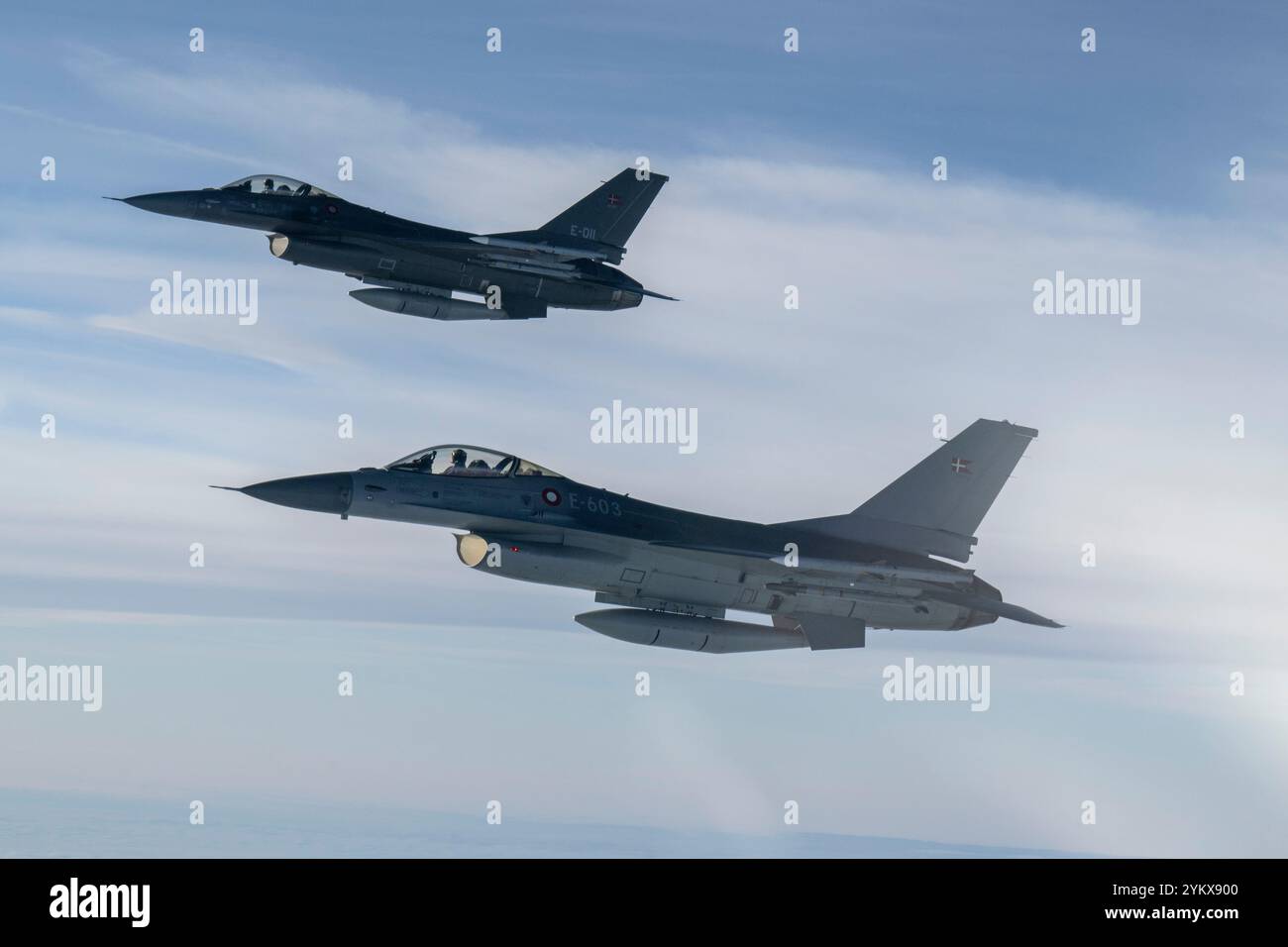 Royal Danish Air Force F-16 Fighting Falcons fly off the wing of a U.S ...