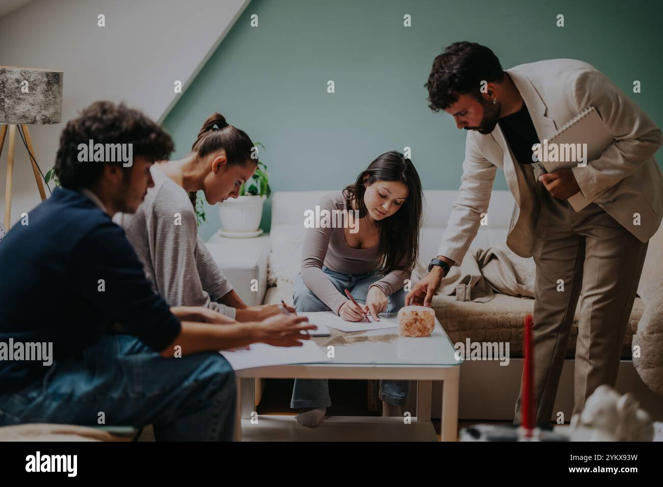 Three high school students work together on a school project with their ...
