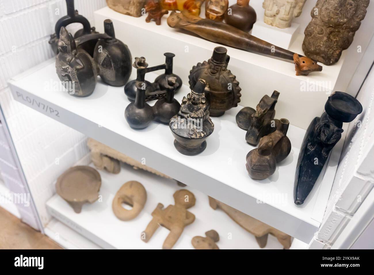 Showcase with aged artifacts in museum of ethnology in Barcelona, Spain ...