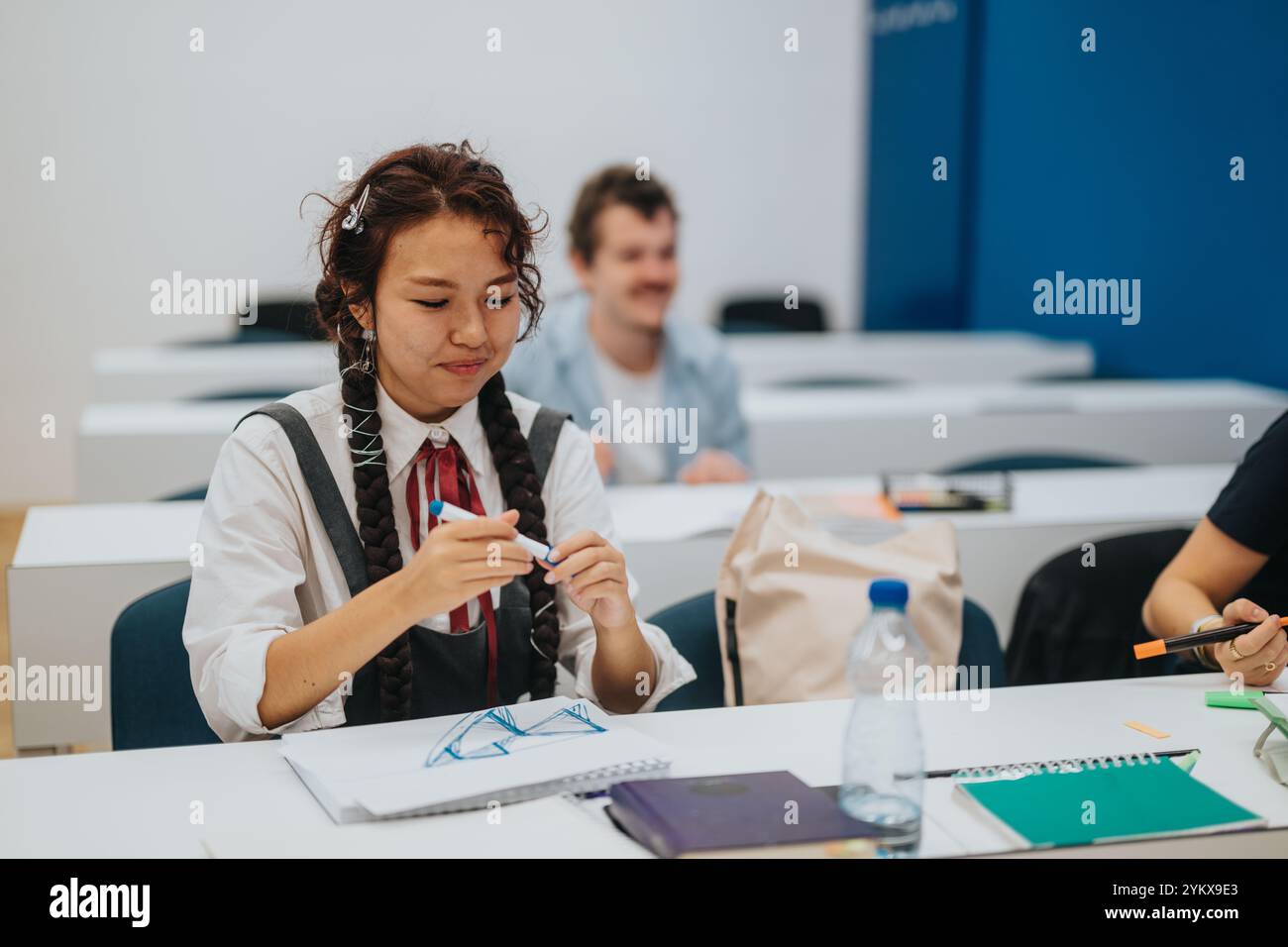 Students working on tasks with professor assistance in classroom ...