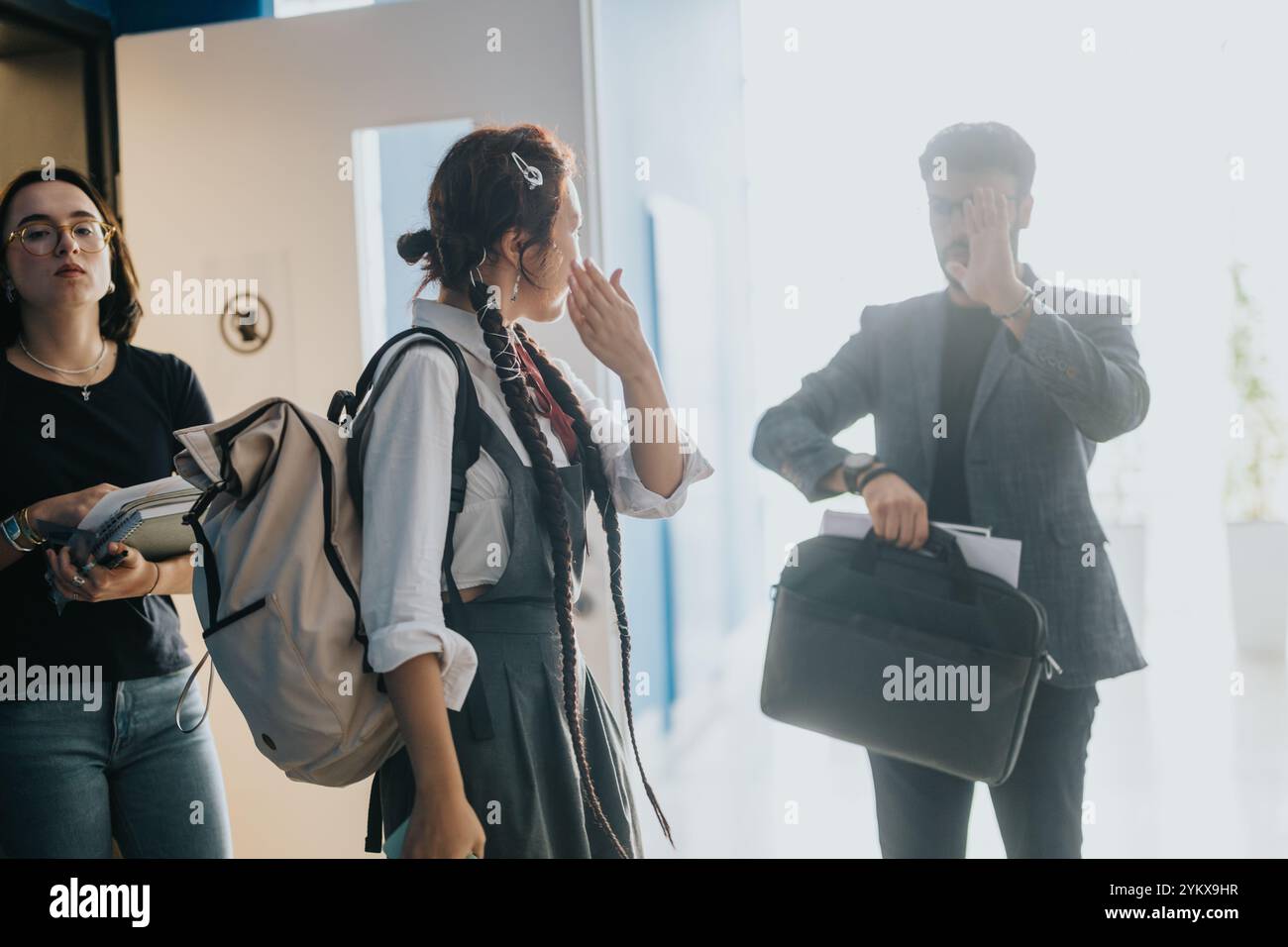 Students discussing with a professor in a college hallway Stock Photo ...