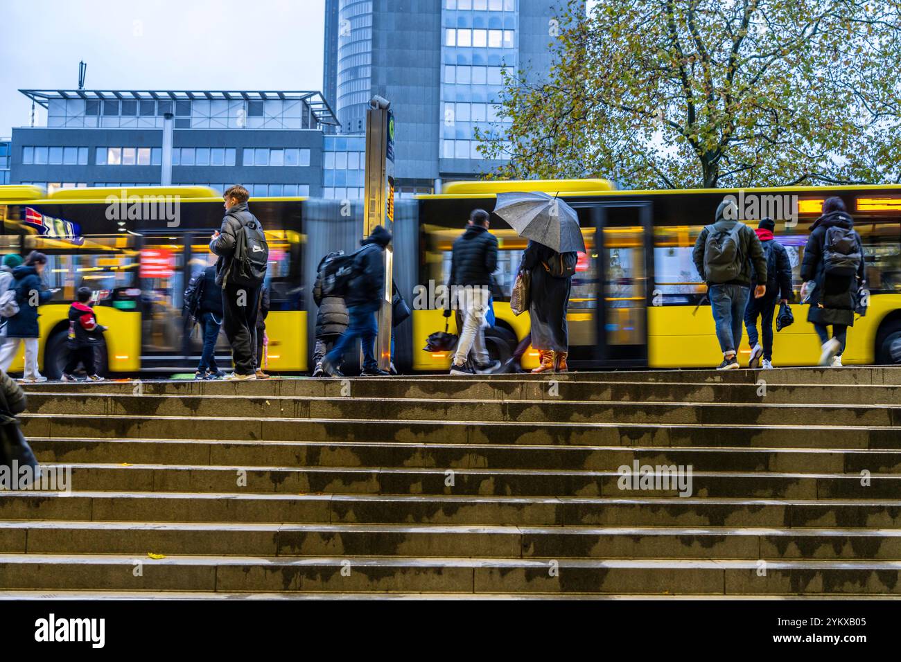 Autumn, rainy weather, bus stop at the central station, passengers ...