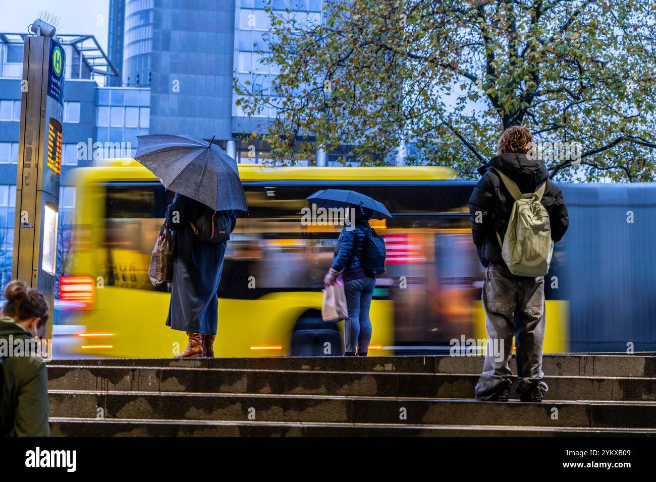 Autumn, rainy weather, bus stop at the central station, passengers ...