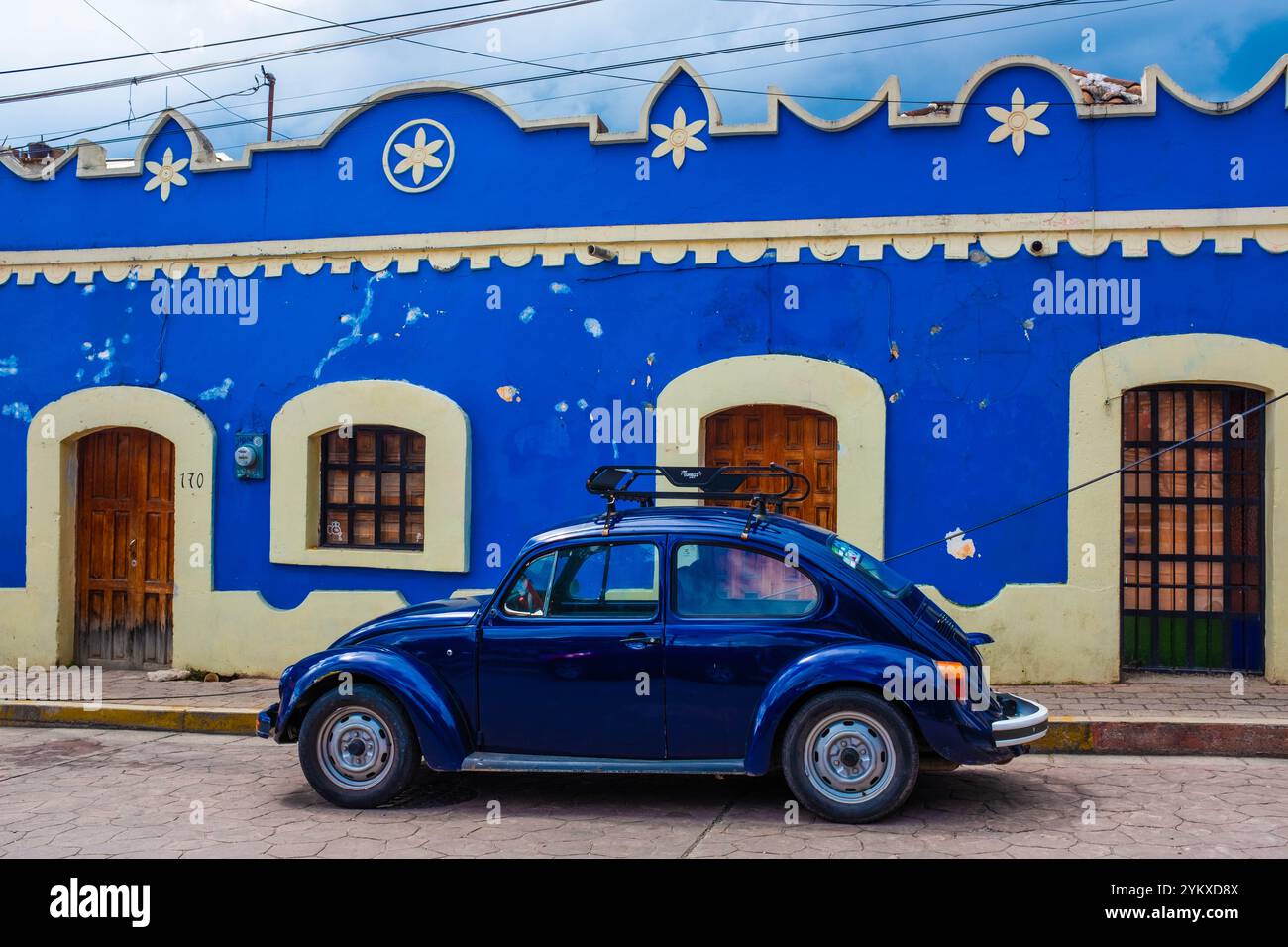 Blue Volkswagen Beetle parked in front of charming blue colonial ...