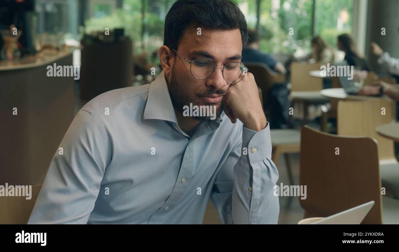 Sleepy tired bored overworked businessman Arabian Indian male business ...