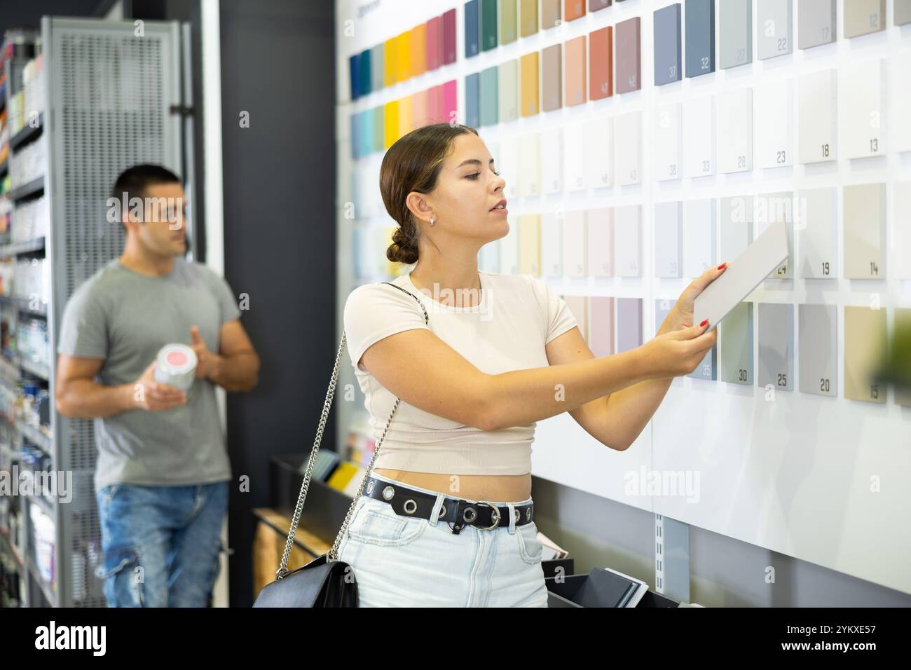 Young woman picking paint colors on stand in construction materials ...